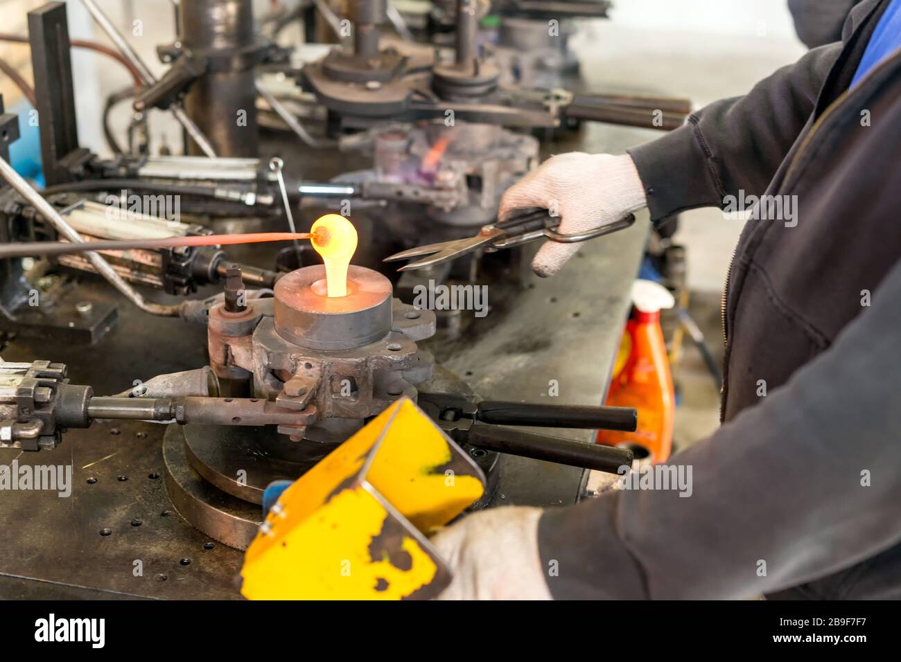 glass bottle production factory - machine blowing of molten glass Stock ...