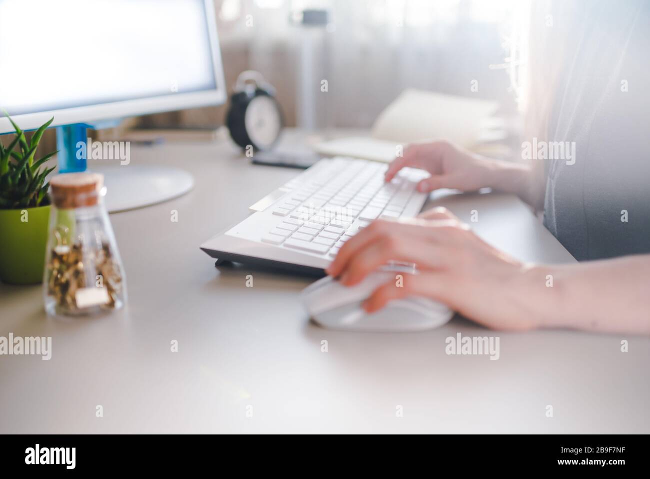 girl typing on a white keyboard and uses mouse Stock Photo - Alamy