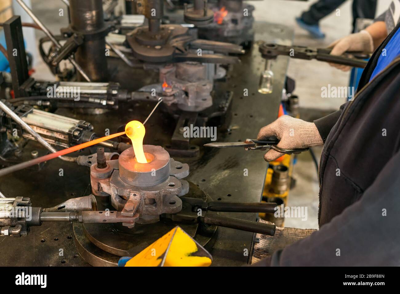 glass bottle production factory - machine blowing of molten glass Stock ...