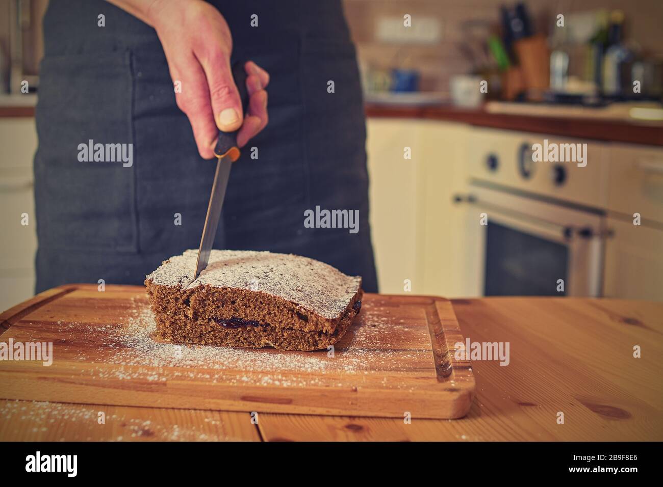 Man cutting classic gingerbread in traditional kitchen. A classic ...