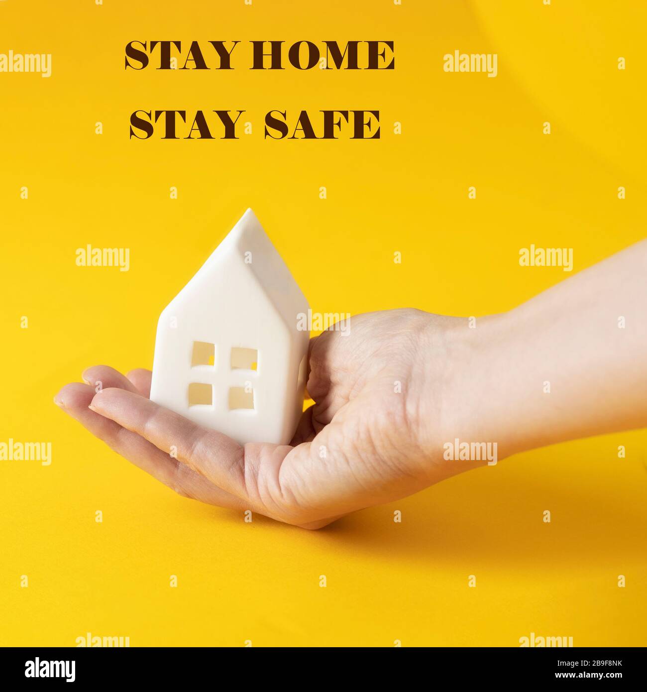 Hand holding house to protect it.stay home stay safe message.Social ...