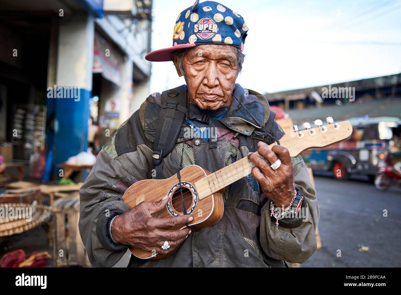 Portrait of a street musician playing guitar in the streets of the ...