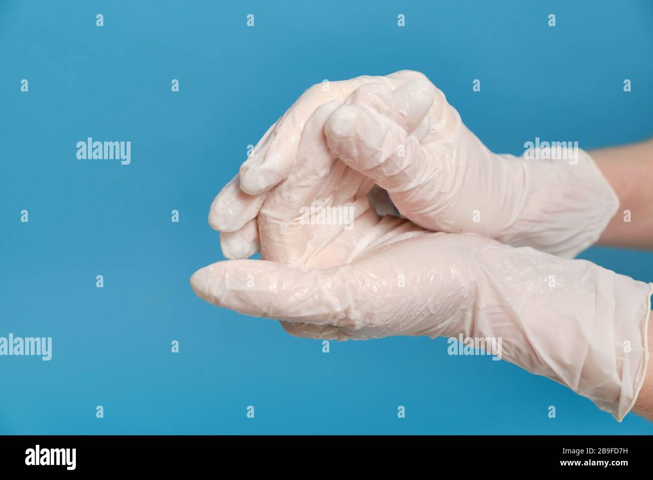 Hand washing in gloves Isolated on a blue background Stock Photo - Alamy