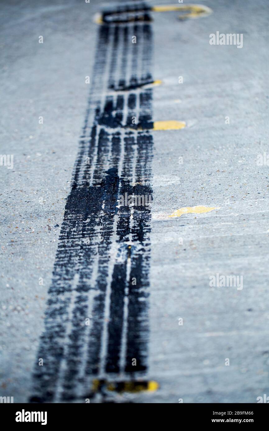 Black tyre marks on a concrete road Stock Photo - Alamy