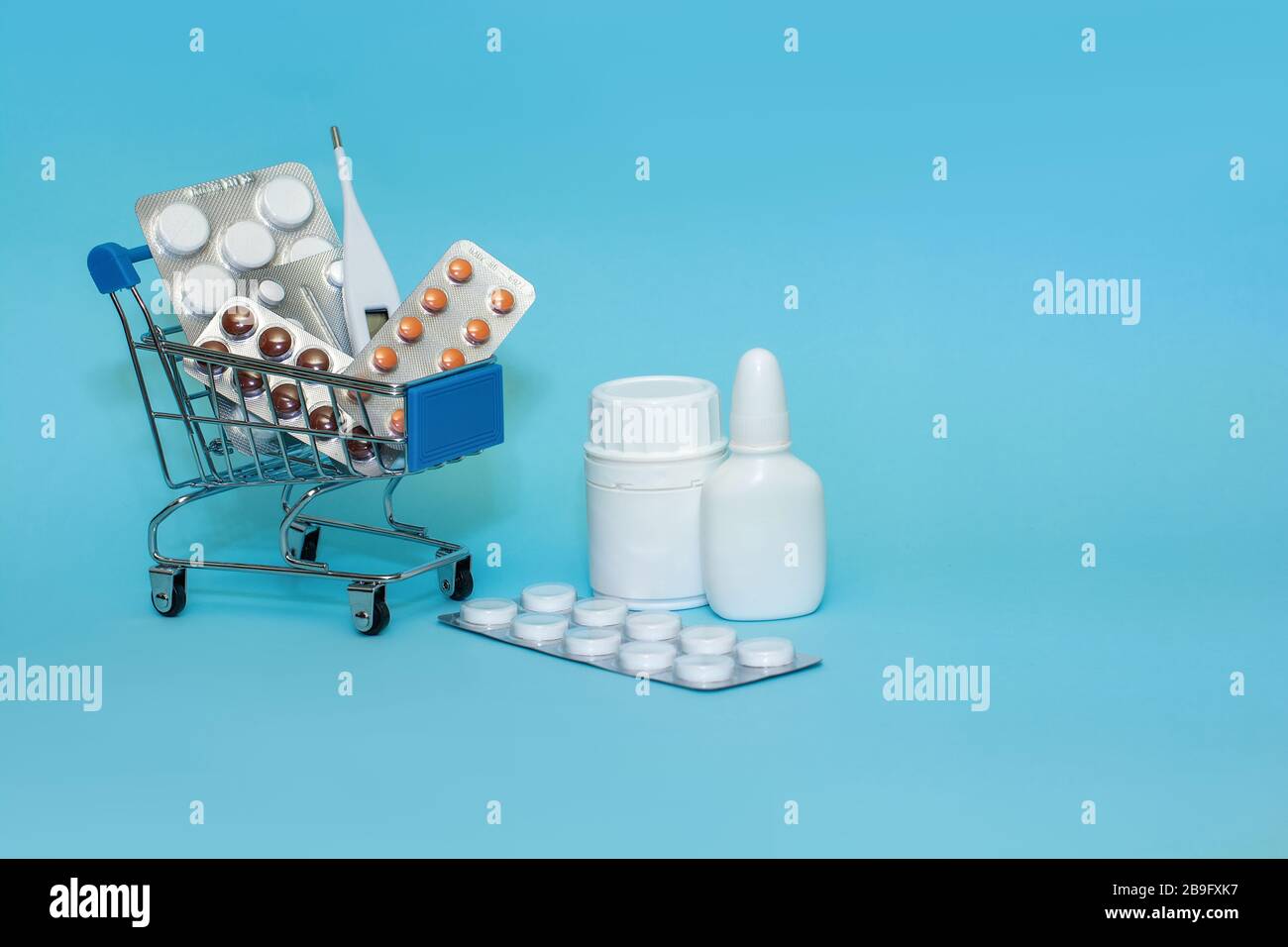 Shopping cart with medicinal pills and thermometer. Spray, vitamins ...