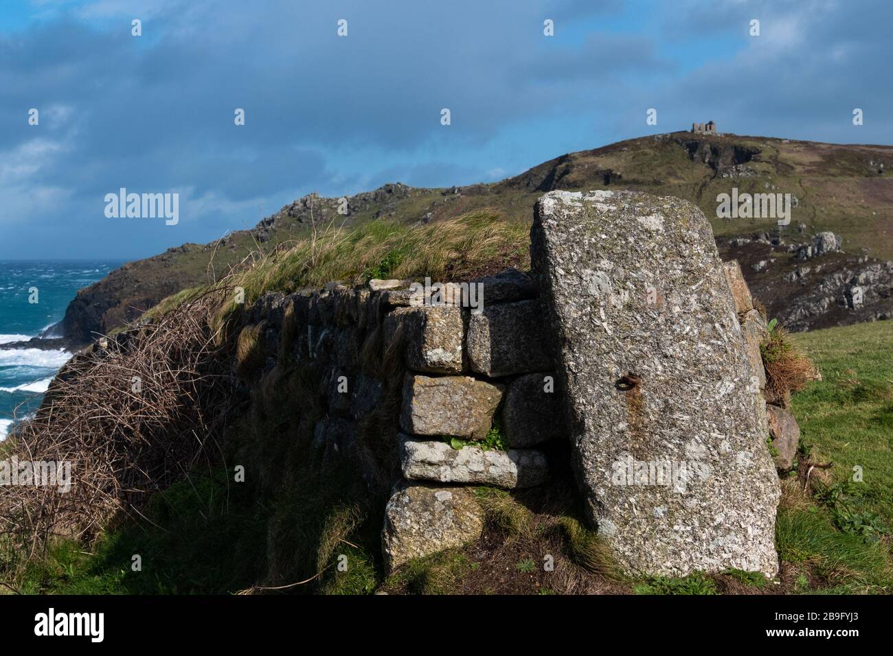 Sunlit view of traditional massive stone and Cornish stone wall against ...