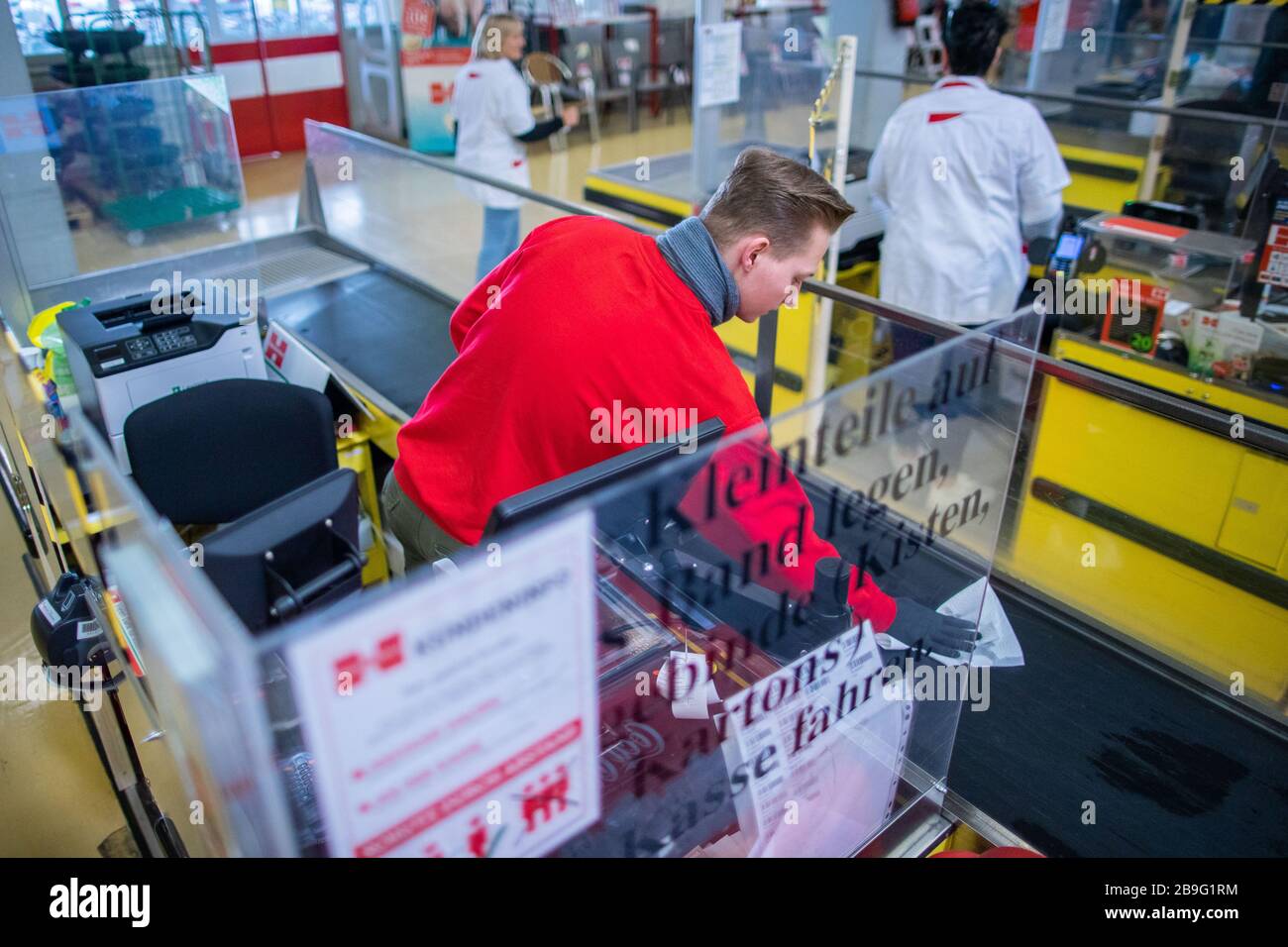 Schwerin, Germany. 24th Mar, 2020. Cashier Sebastian Adamek cleans the ...