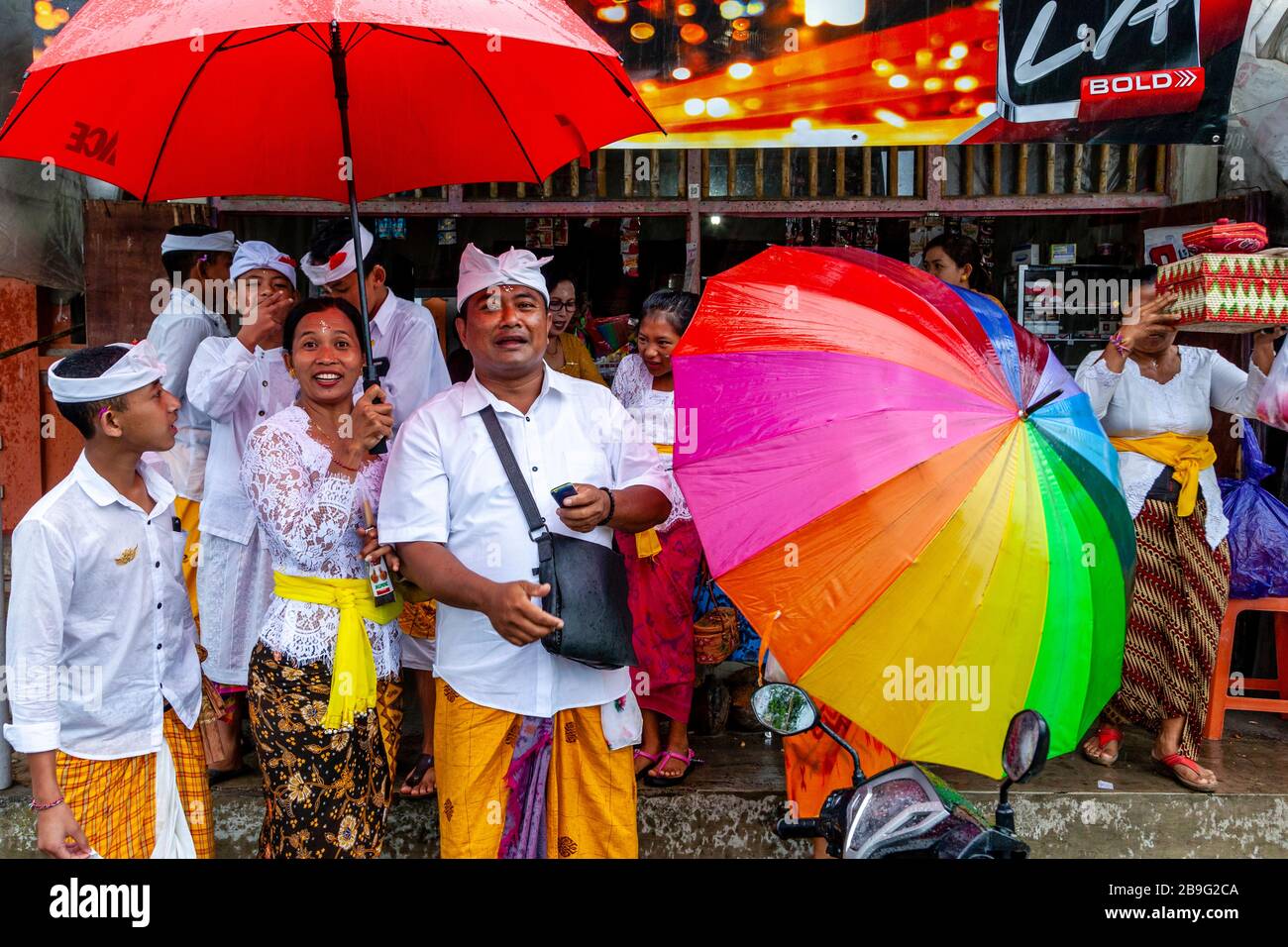 A Group Of Colourfully Dressed Balinese Hindu People Standing By A ...