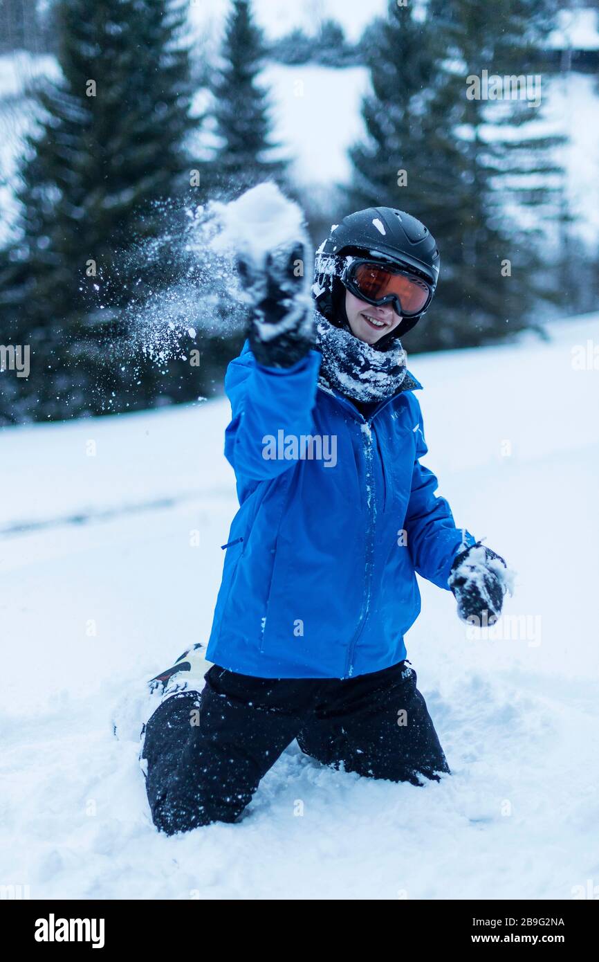 Boy in safety helmet is throwing snowball hi-res stock photography and ...