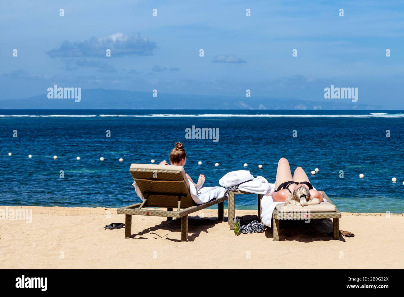 Two young women sunbathing at the beach hi-res stock photography and ...