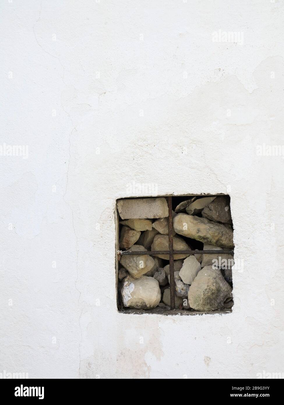 Square opening in wall with stacked rocks Stock Photo - Alamy