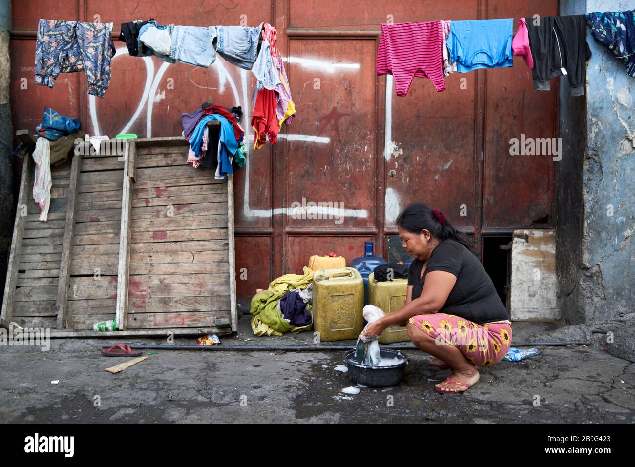 Woman washing clothes in bucket hi-res stock photography and images - Alamy