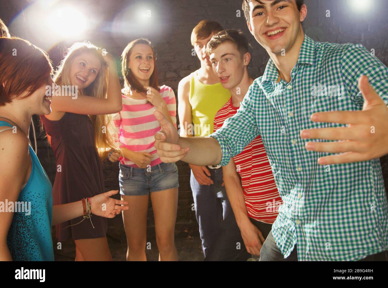 Happy teenage friends dancing at party Stock Photo - Alamy