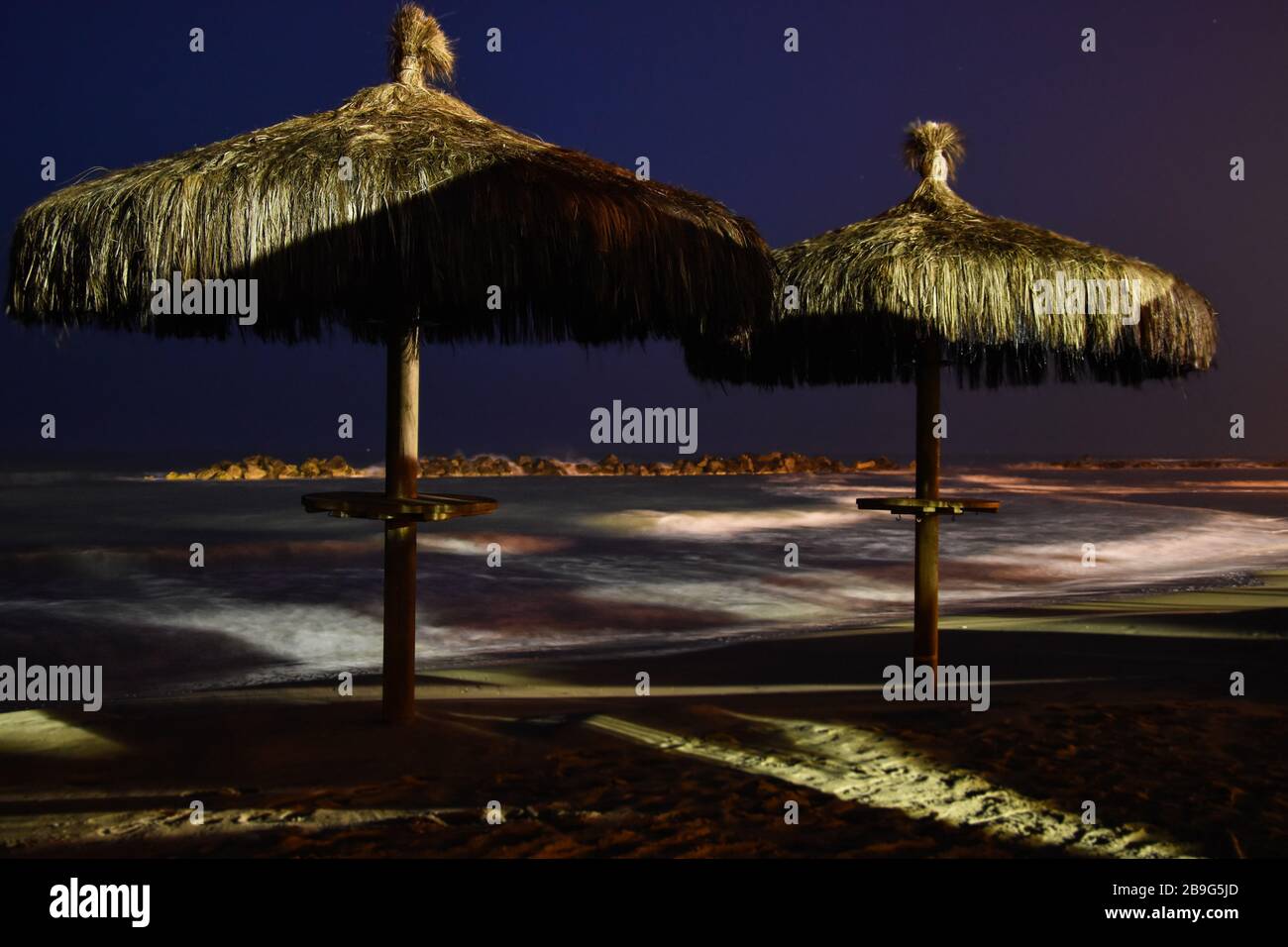 Magic evening beach with umbrellas in Italy Stock Photo - Alamy