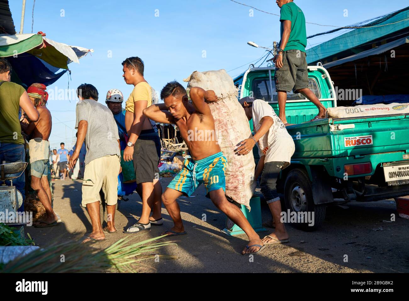 Porter carrying a heavy load in the streets of the Carbon public market ...