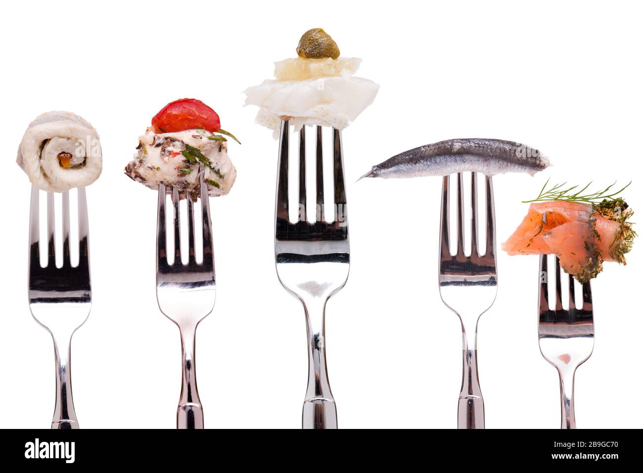 Different fishes on fork white isolated Stock Photo - Alamy