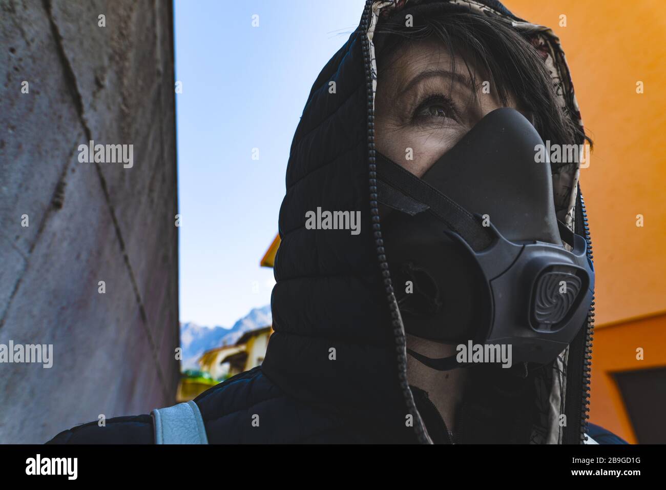 woman with a gas mask walking on the city streets surviving a corona ...