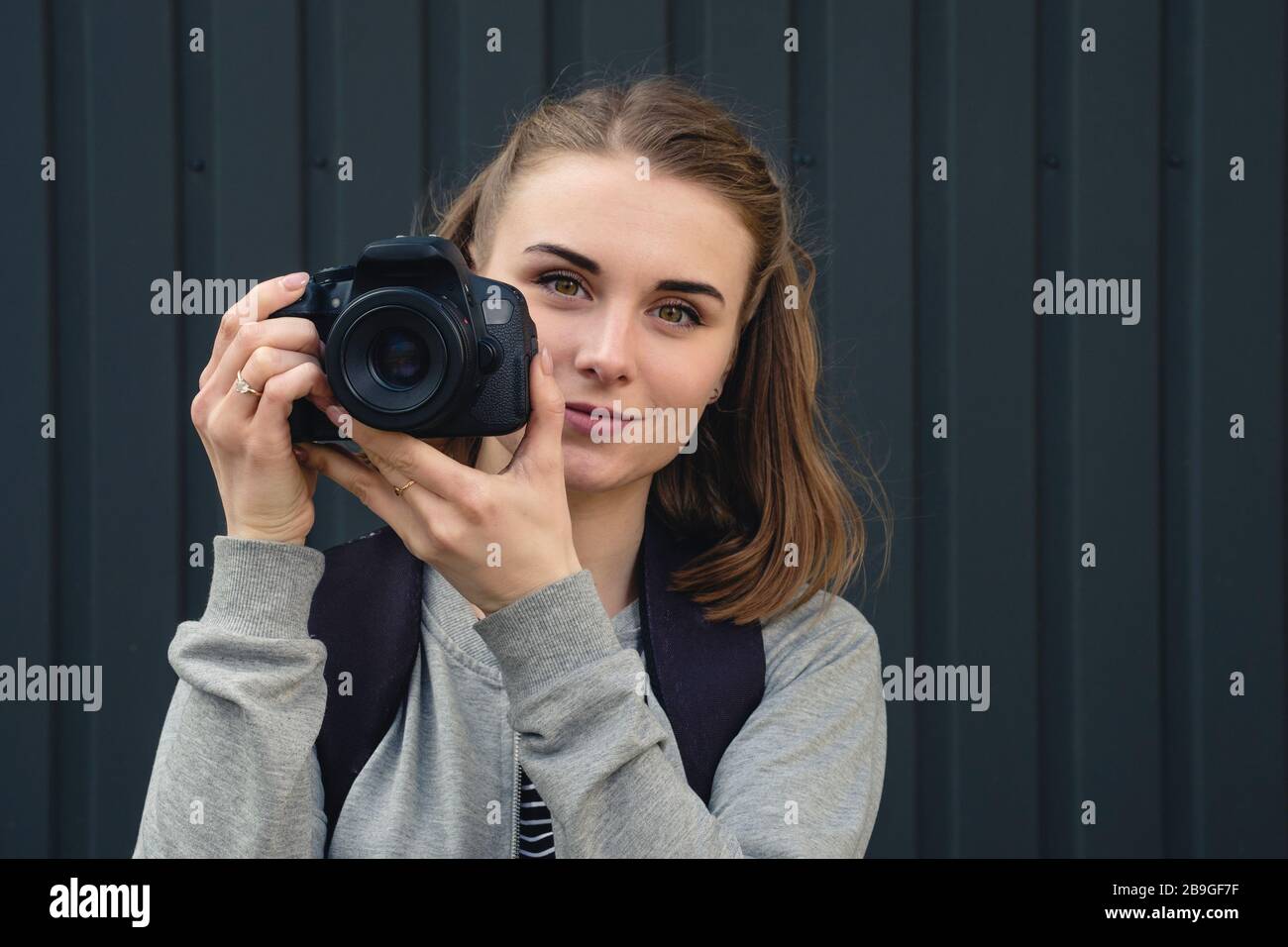 Young woman taking a photograph on a camera Stock Photo - Alamy