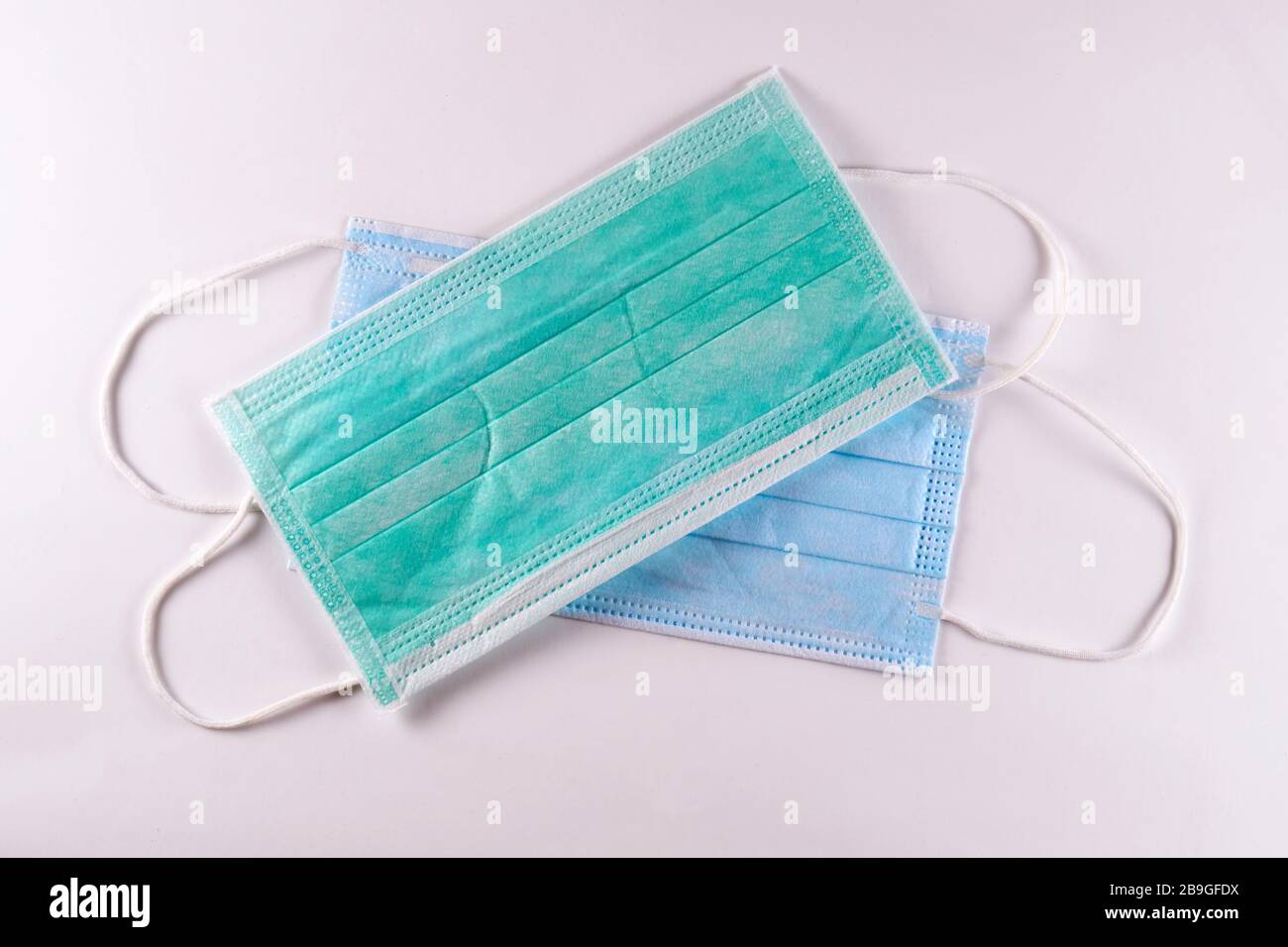 Two surgical breathing masks green and blue (top view on white ...