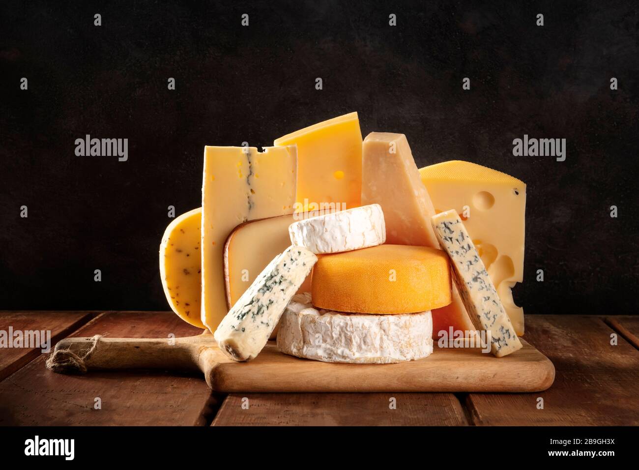 Cheese variety, many different types of cheeses, a side view on a dark ...