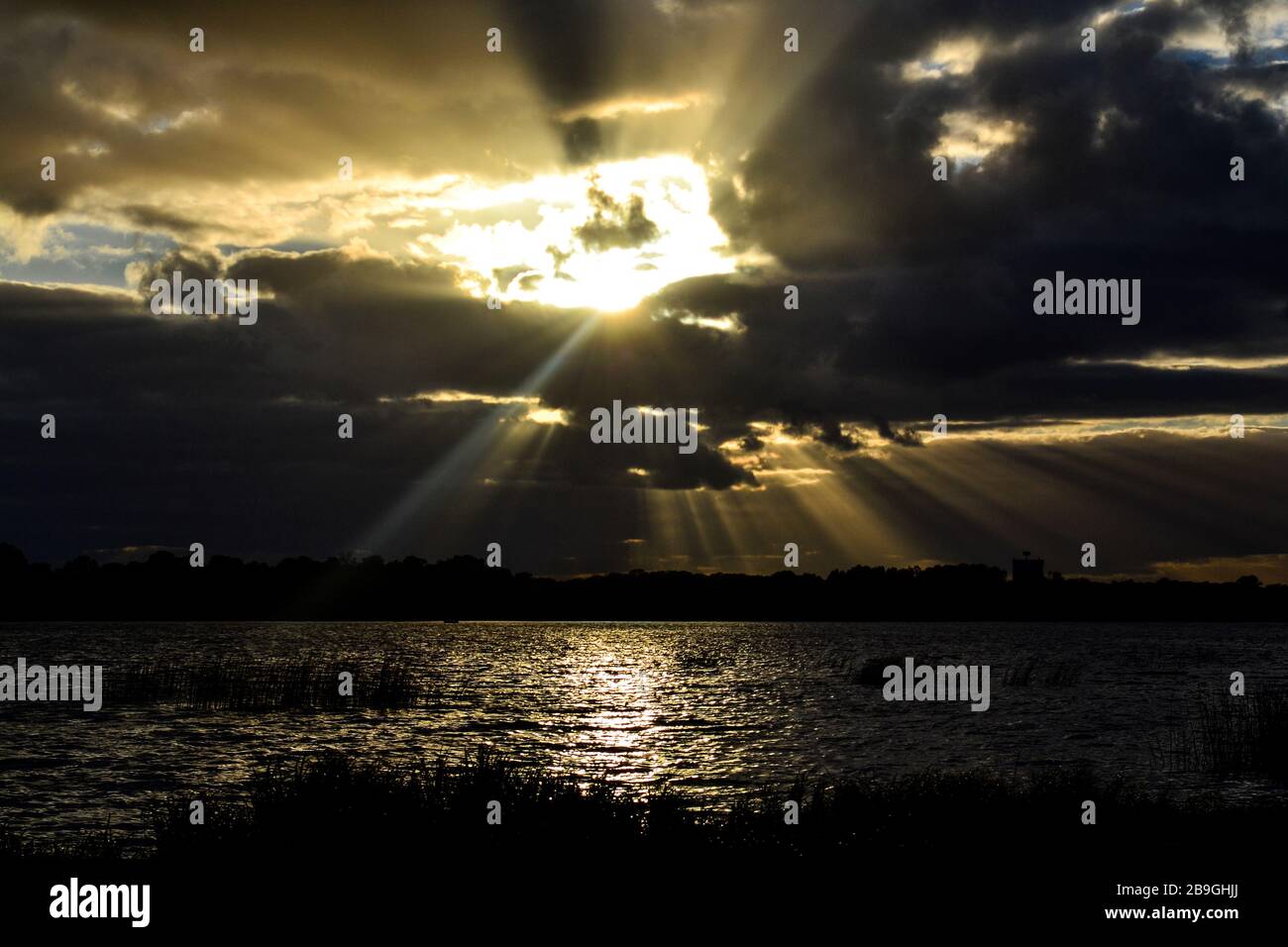 Beautiful sunset landscape with sun rays shining through the clouds ...