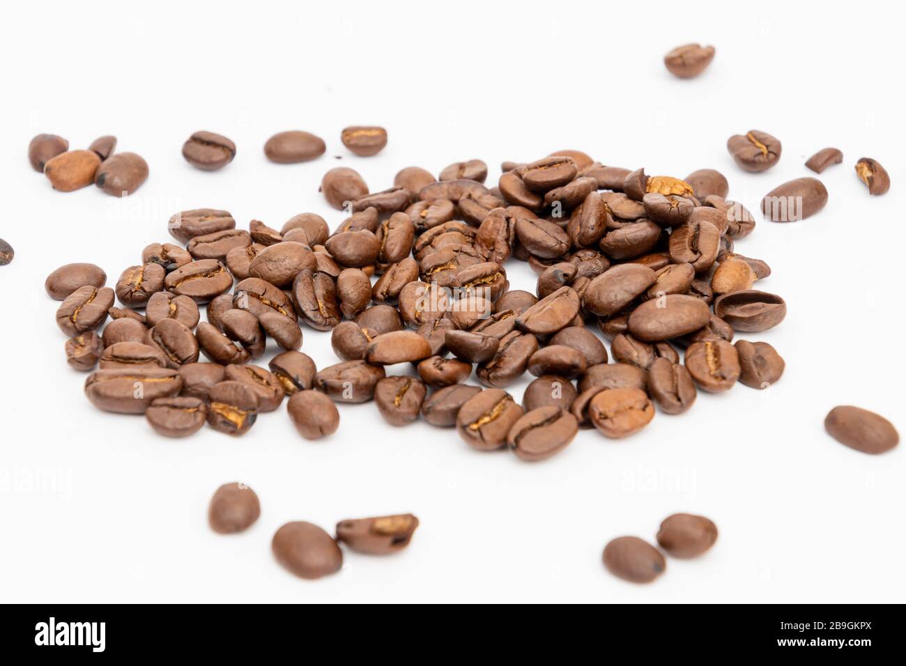 Roasted coffee beans spread out on a white underground Stock Photo - Alamy