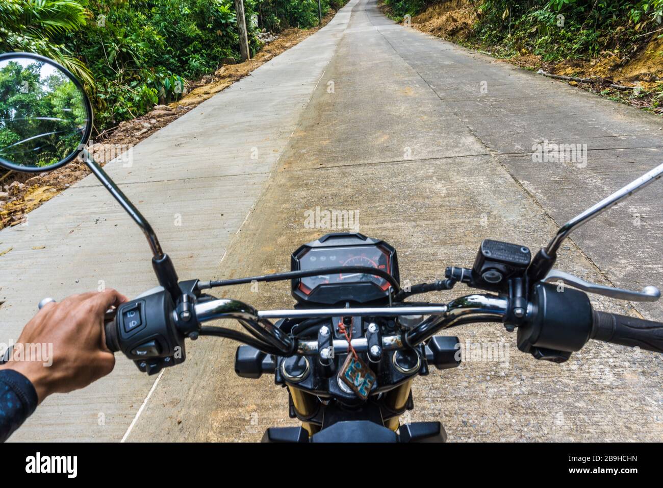 Front side of man drive motorcycle in rural country road deep forest ...