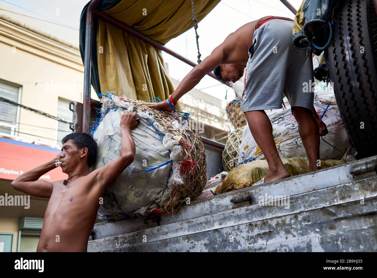 Porter carrying a heavy load in the streets of the Carbon public market ...