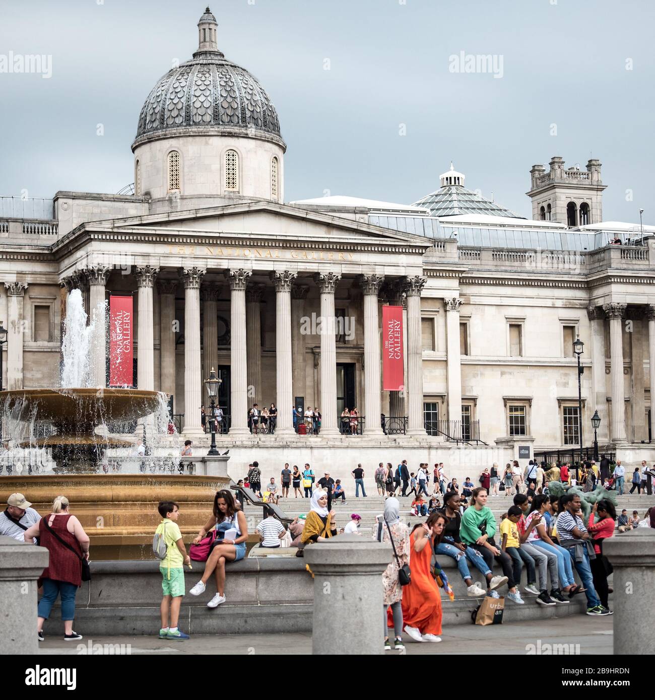 Trafalgar Square and the National Gallery. Tourists sitting around a ...