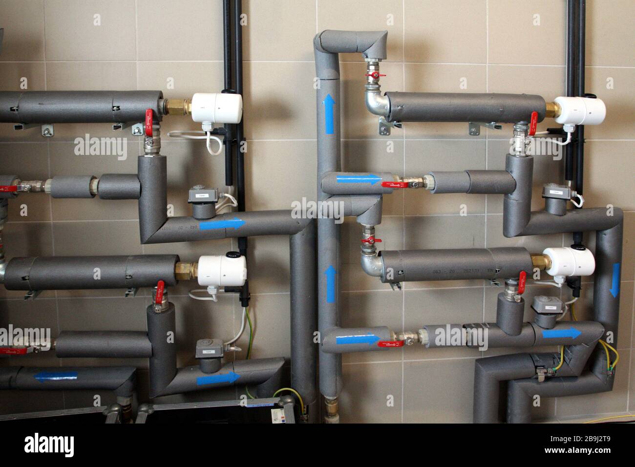 Pipes and valves of water circuit against the wall Stock Photo - Alamy