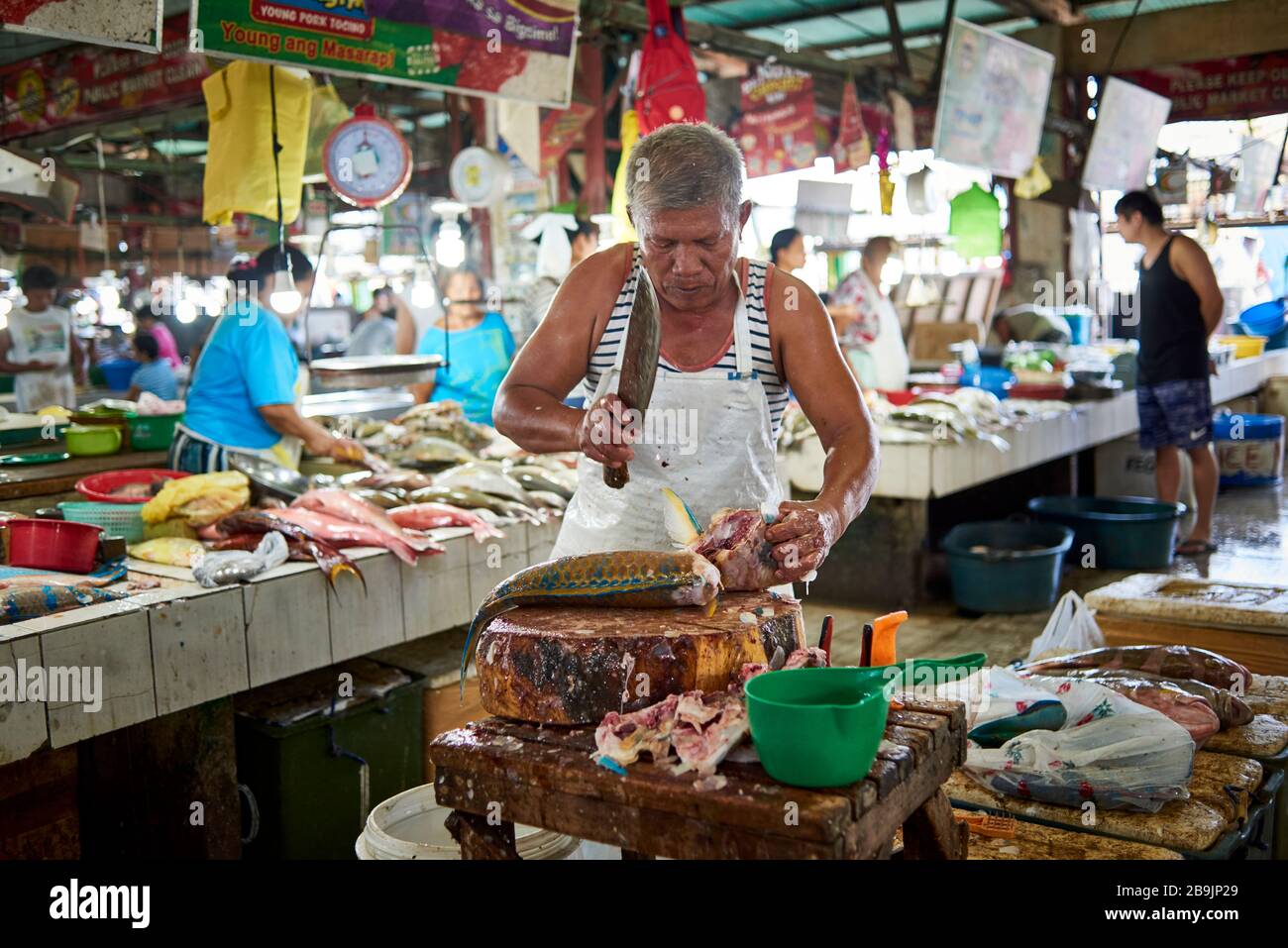 Fishmonger cutting fish inside the fish section of the Carbon public ...