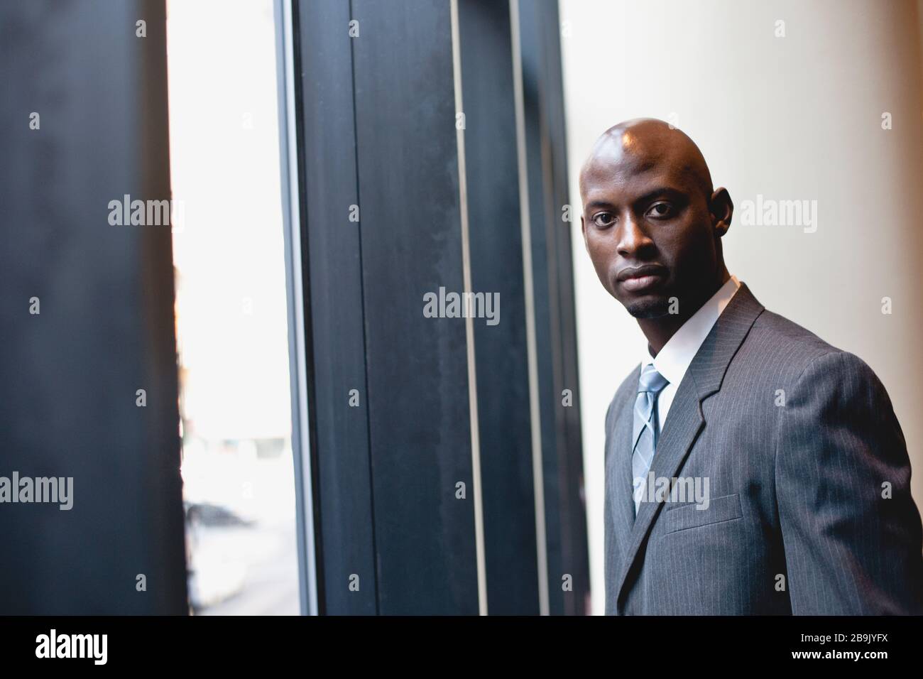 Man standing beside window Stock Photo - Alamy