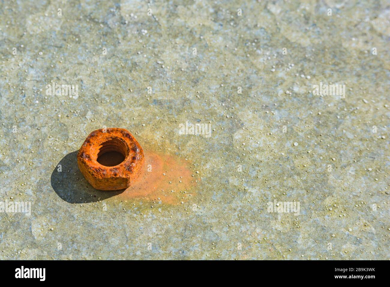 Close-up shot of rust encrusted / rusty steel bolt on galvanized steel ...