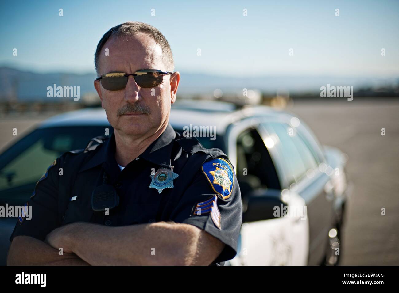 Portrait of policeman in front of his police car Stock Photo - Alamy