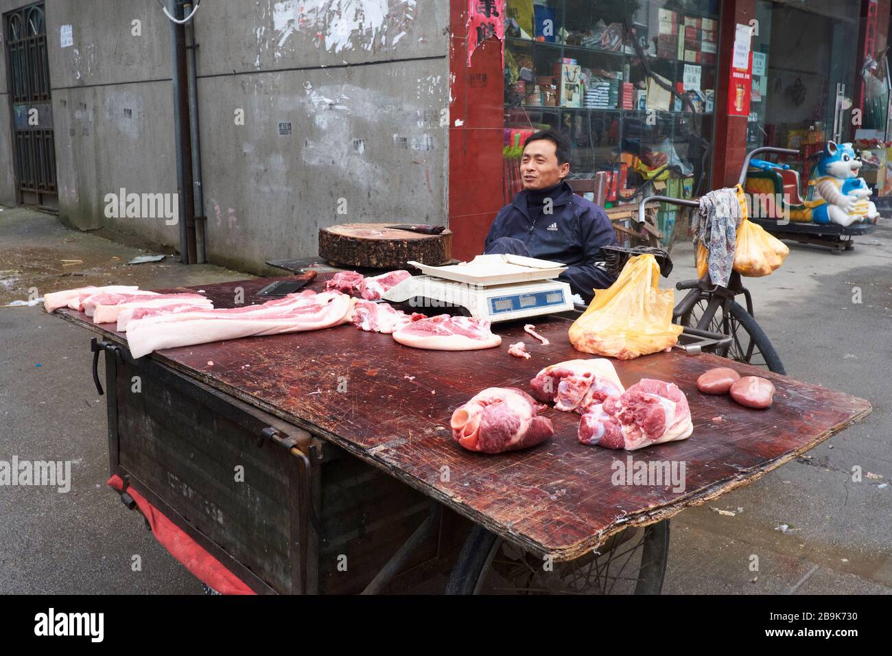 A butcher selling meat on the street in the Chinese city of Huangshi ...