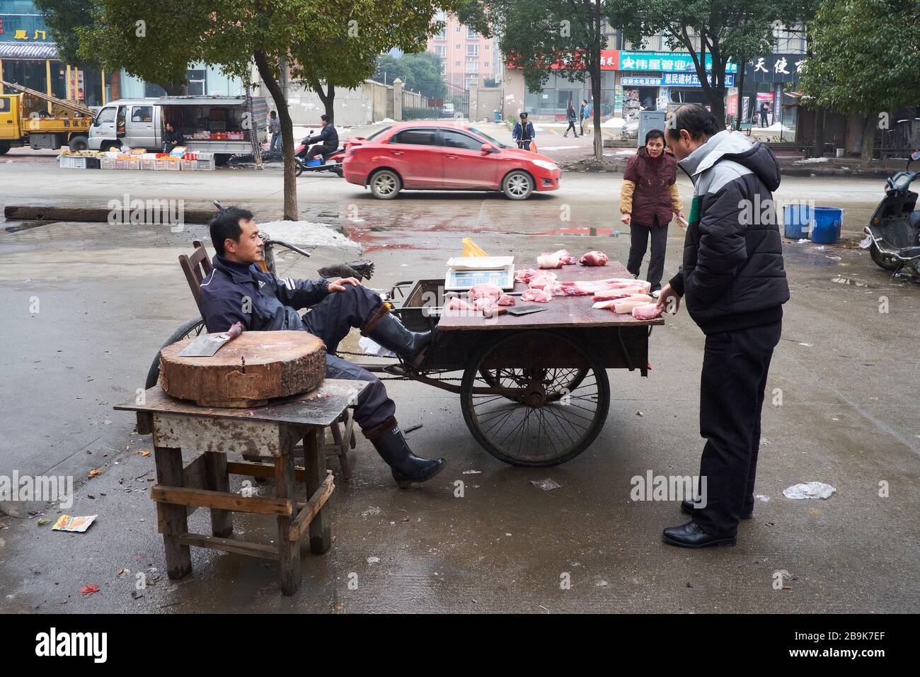 A butcher selling meat on the street in the Chinese city of Huangshi ...