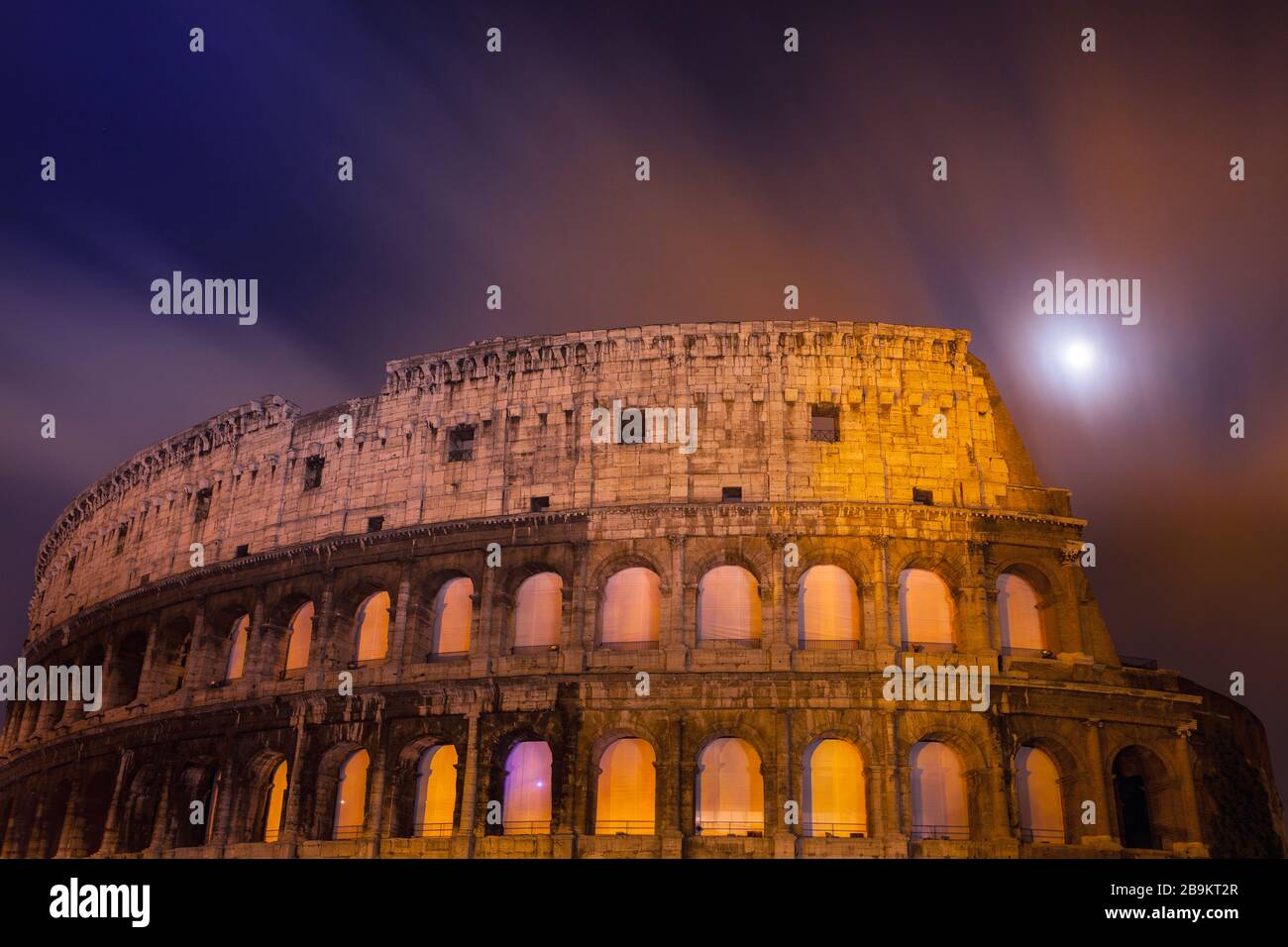 The Colosseum at night with a full moon in long exposure with trails ...