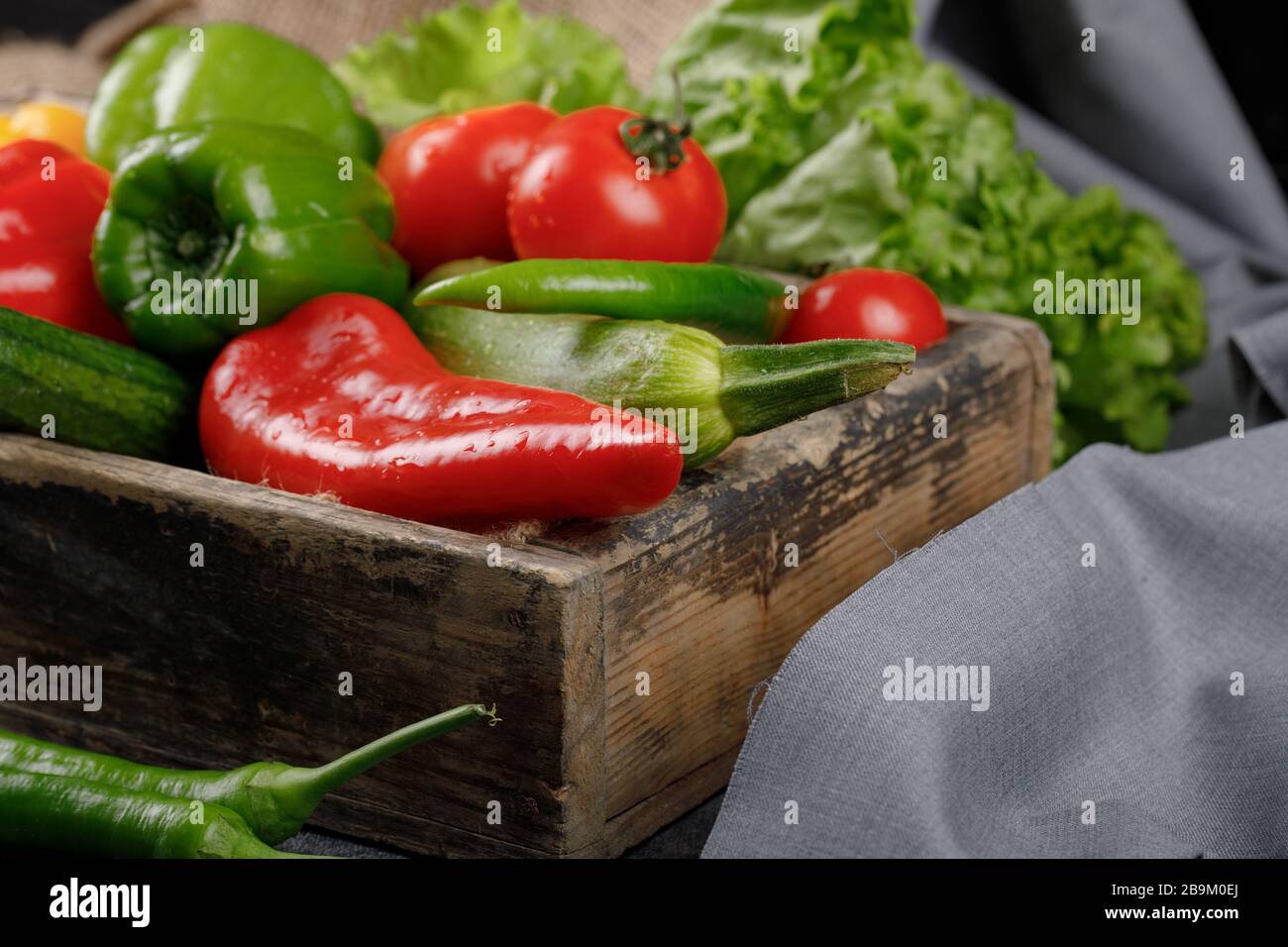 Colorful chili peppers in a rustic wooden tray Stock Photo - Alamy