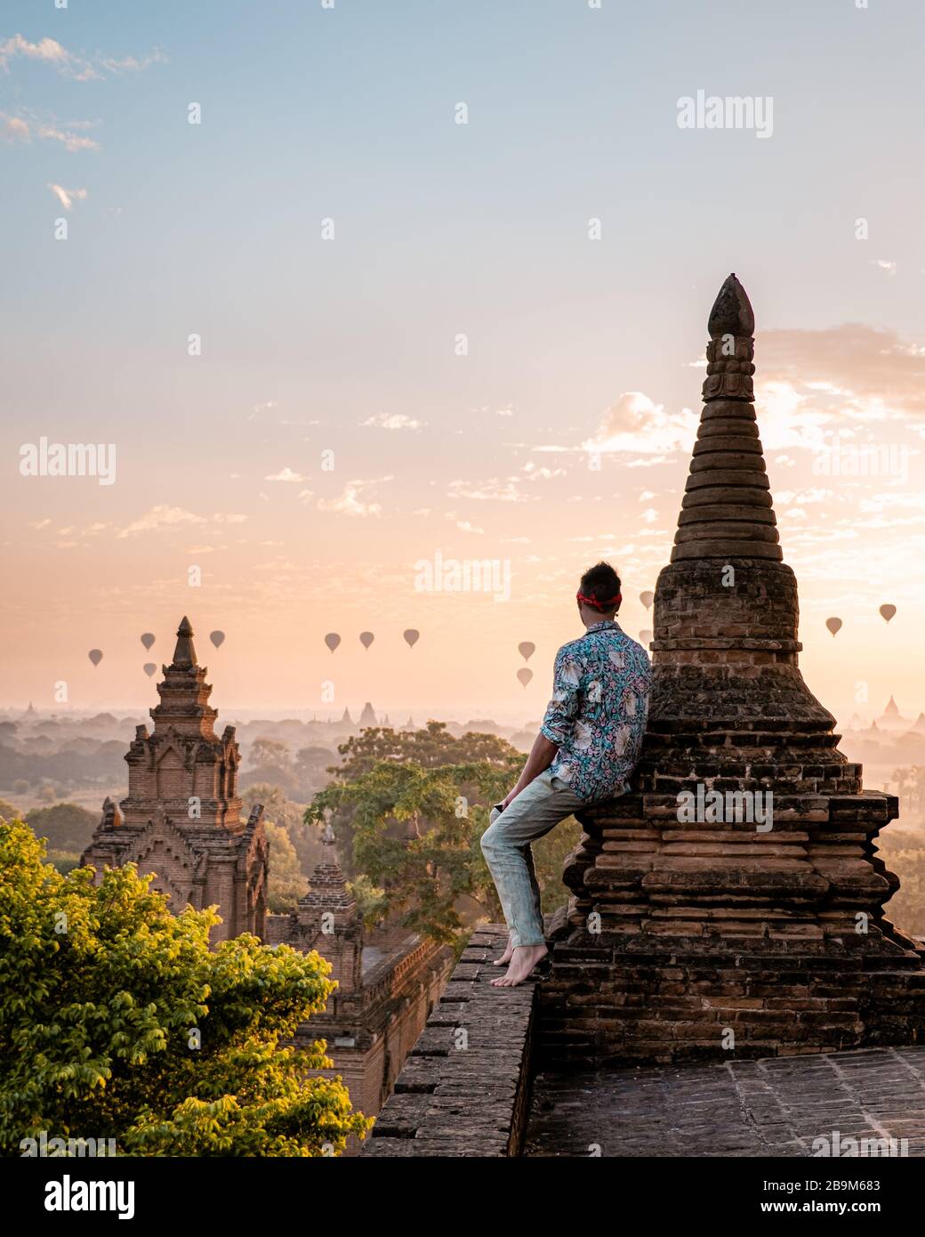 Bagan Myanmar young men watching Sunrise from the roof top of an ...