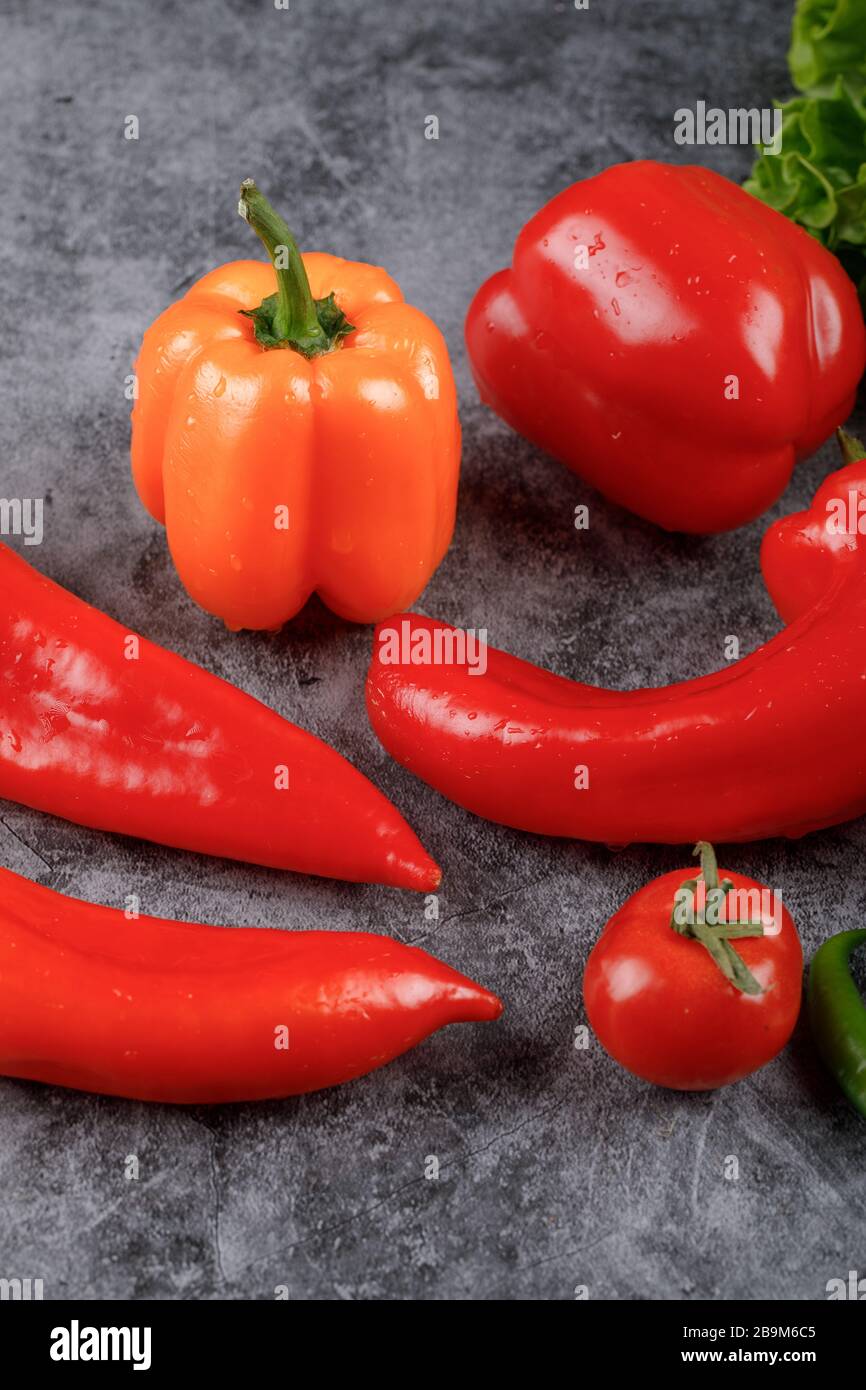 Red and yellow vegetables on the grey table Stock Photo - Alamy
