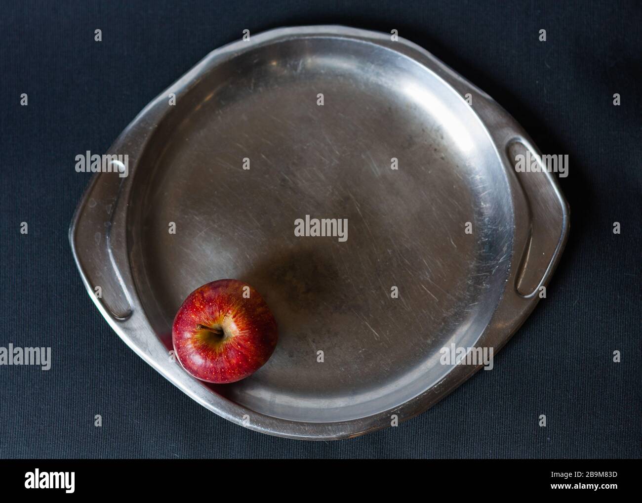 Red apple on old steel plate and black background. Top view ...