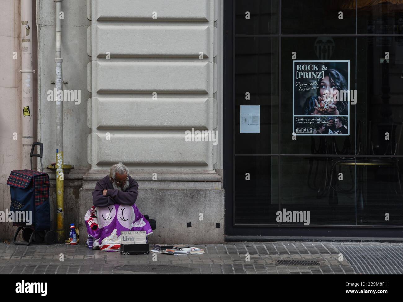 homeless person asks in the empty streets of the city for the ...