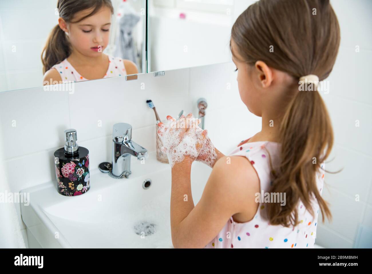 Little girl washing hands with water and soap in bathroom. Hands ...