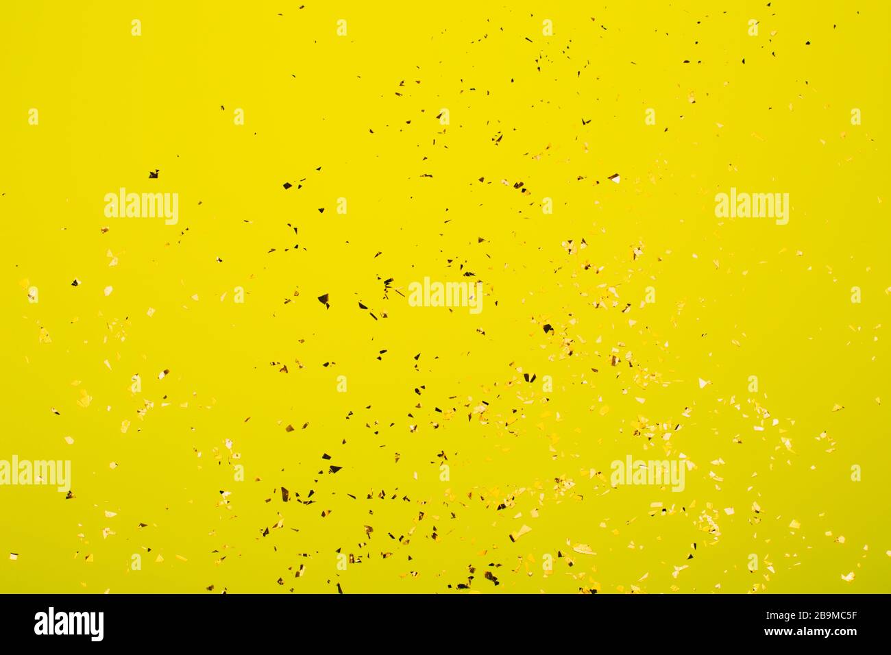 Golden flying sparkles on bright yellow background. Festive backdrop ...