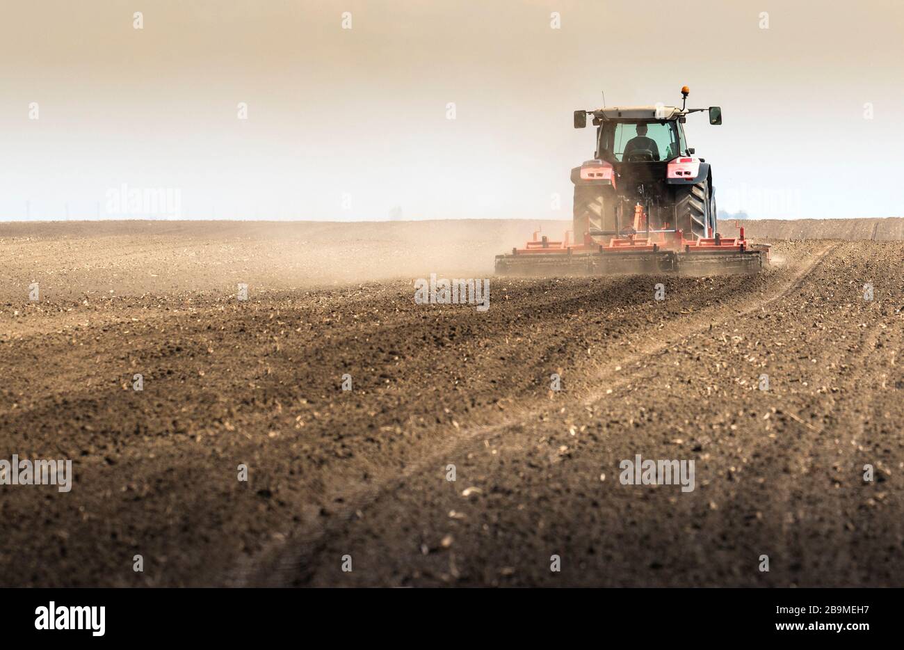 Farmer preparing his field in a tractor ready for spring Stock Photo ...