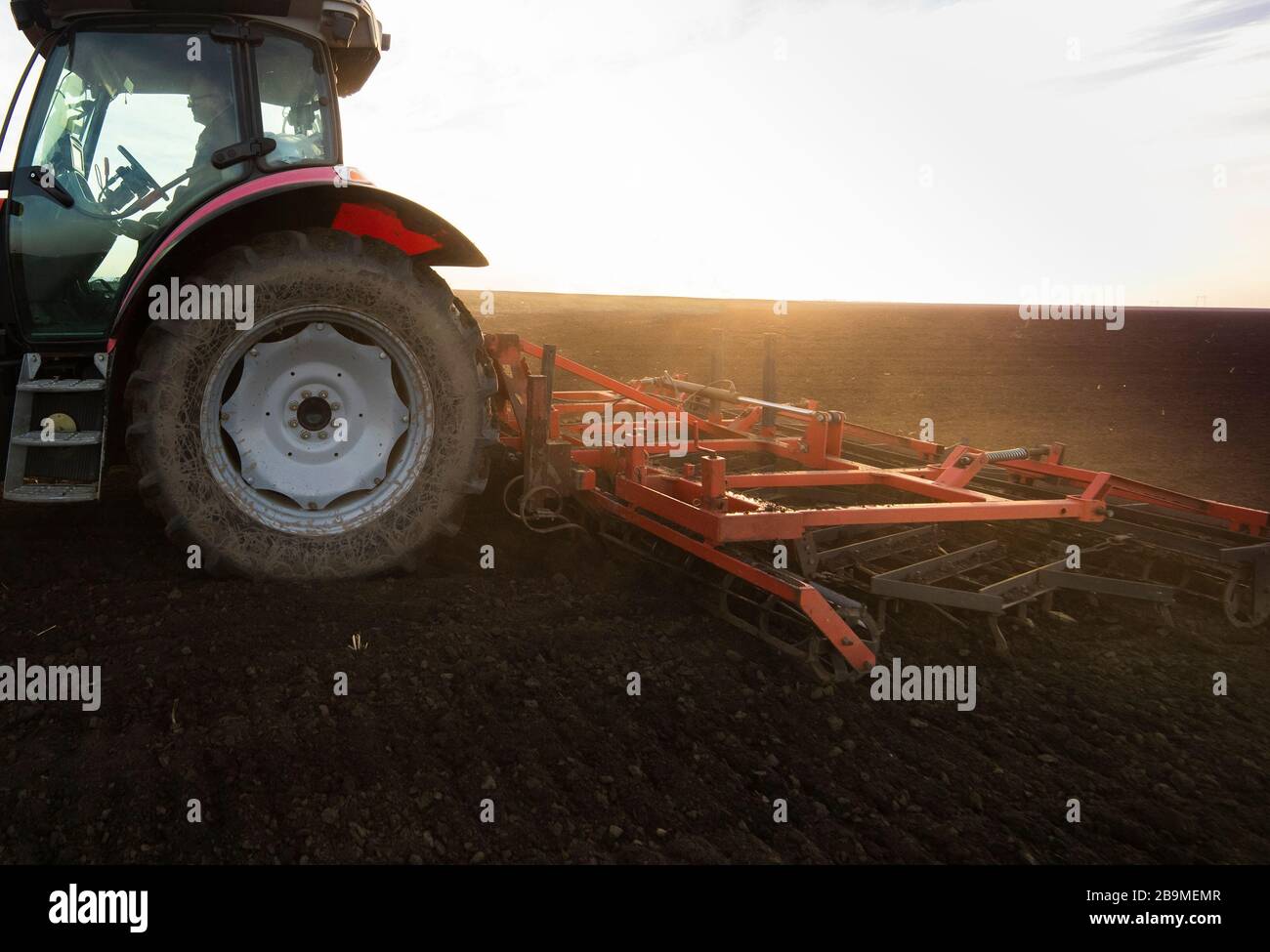 Farmer preparing his field in a tractor ready for spring Stock Photo ...