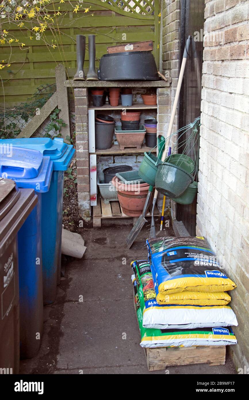 Simple garden shelves with pots, gumboots and compost Stock Photo - Alamy