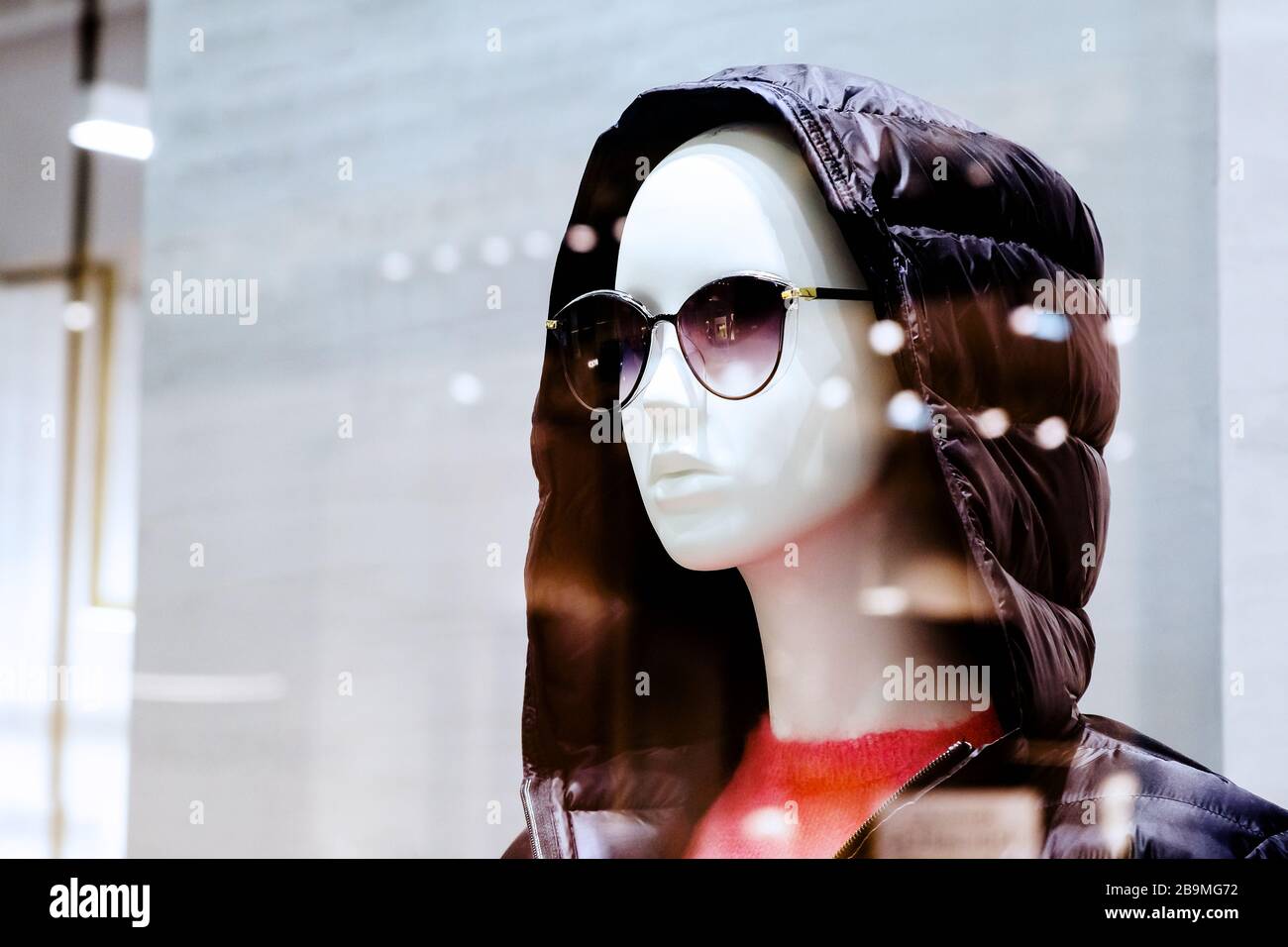 A jacket with a hood on the mannequin's head. Boutique in a shopping ...