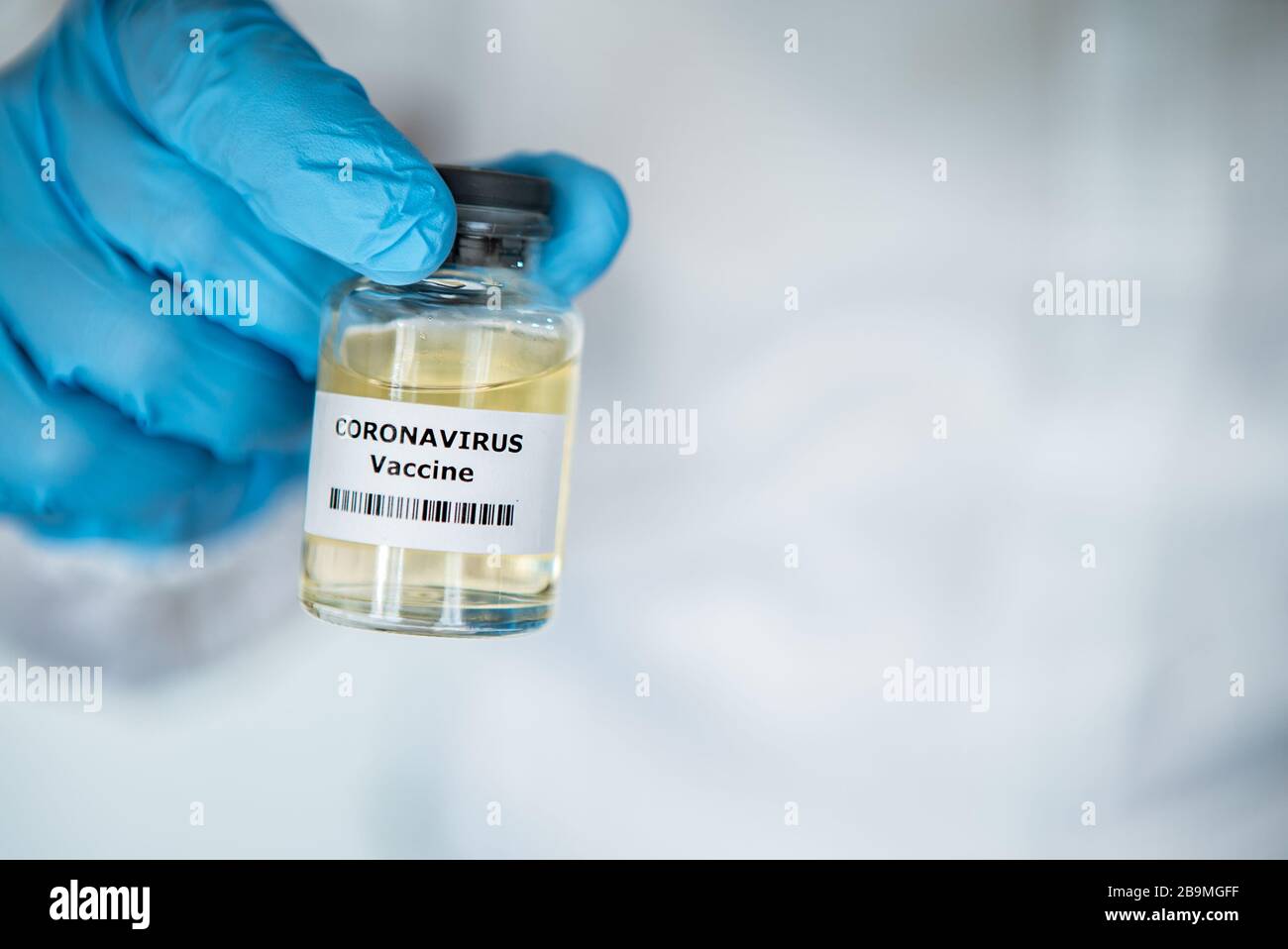 Doctor in a protective suit with a vaccine vial coronavirus. Preventive ...