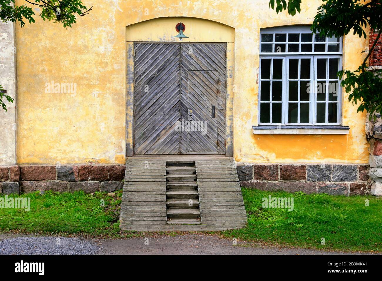 Facade of old yellow stone building in Suomenlinna, Finland with arched ...